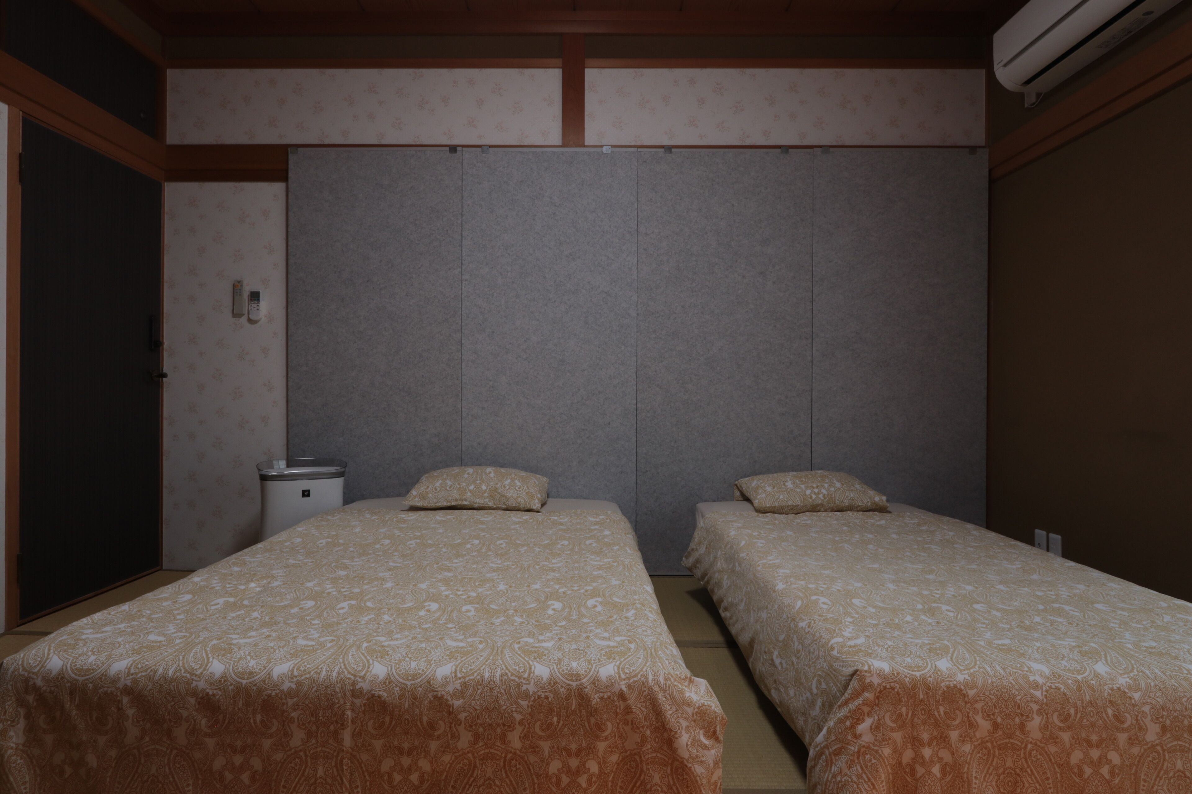 Quarto com duas camas, um guarda-roupa e ar condicionado.