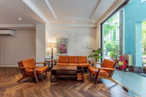 Uma sala de estar moderna com um sofá de couro, mesa de centro de madeira e poltronas combinando.