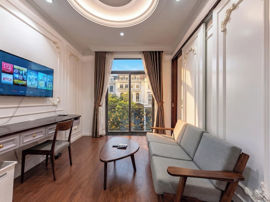 Uma sala de estar moderna com televisão de tela plana, um sofá, uma mesa de centro e uma escrivaninha com uma cadeira.