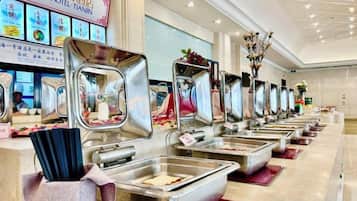 Disposição de buffet com várias estações de serviço, cada uma com frente espelhada e bandejas de aço inoxidável.