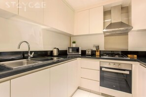Um frigorífico, um micro-ondas, um forno, uma placa de cozinha 