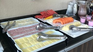 Uma mesa de buffet com diversos alimentos e utensílios de servir.