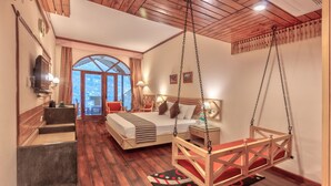 Quarto com cama, mesa de cabeceira, luminária e cadeira suspensa.