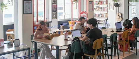 Um espaço de coworking moderno com mesas, cadeiras e pessoas trabalhando em laptops.
