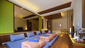 Quarto de hotel moderno com uma cama grande, piso de madeira e um espelho amplo.