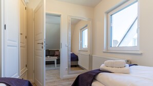 Quarto com uma janela grande, um espelho e vista para o exterior.
