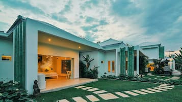 Uma casa moderna com um pátio amplo, uma grande janela e um jardim bem cuidado.