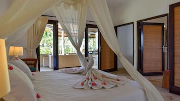 Um quarto espaçoso com uma cama grande, um dossel e vista para o exterior.