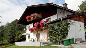Um edifício de dois andares com uma varanda decorada com cestos de flores.