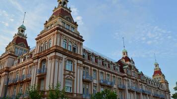 Um edifício grande e ornamentado, com várias varandas e uma torre imponente.