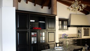 Uma sala de jantar com uma mesa posta para quatro pessoas, ladeada por armários de madeira escura com portas de vidro.