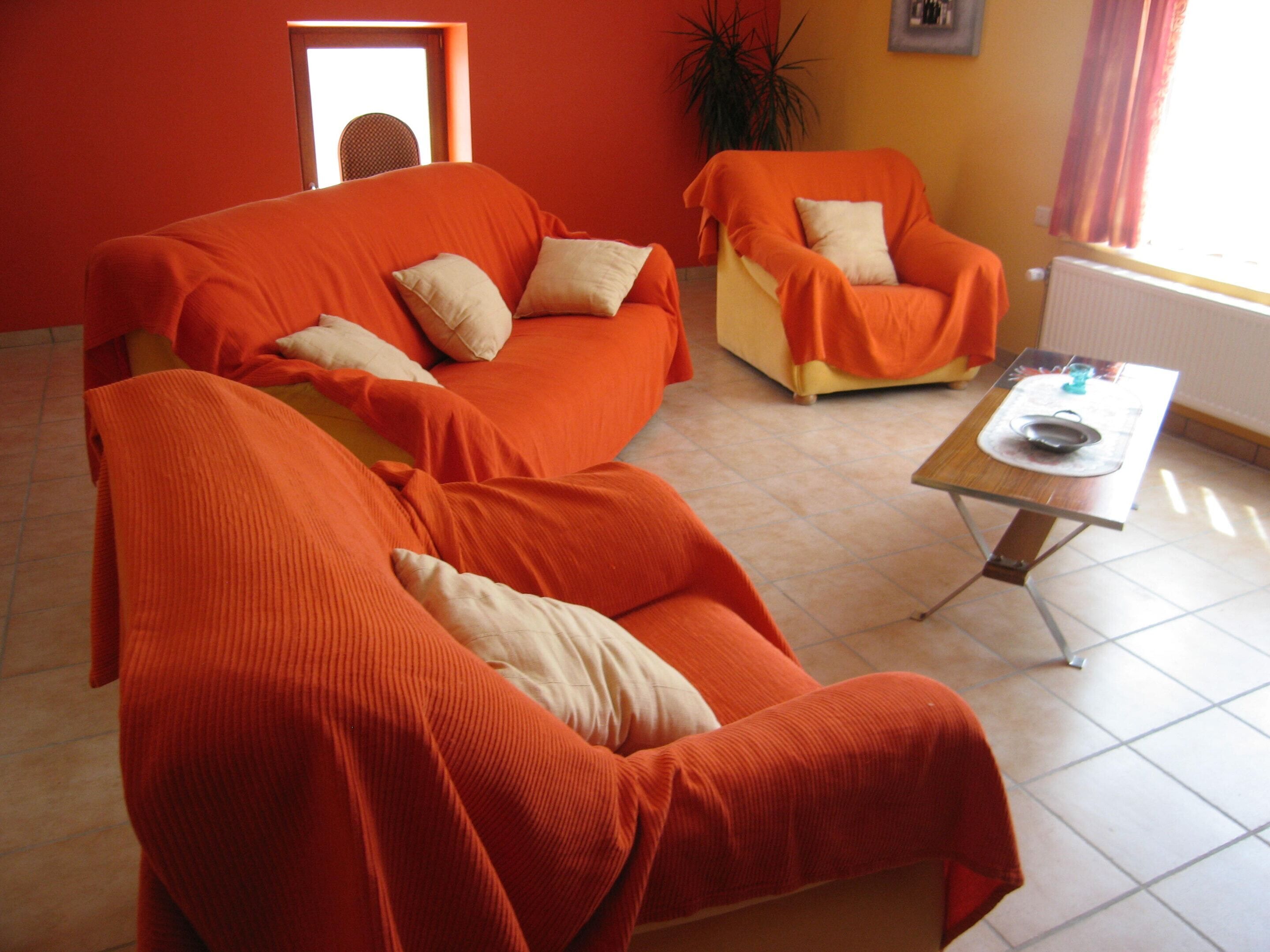 Uma sala de estar com sofá, poltronas e mesa de centro.