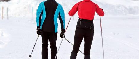 Duas pessoas esquiando em um caminho coberto de neve.