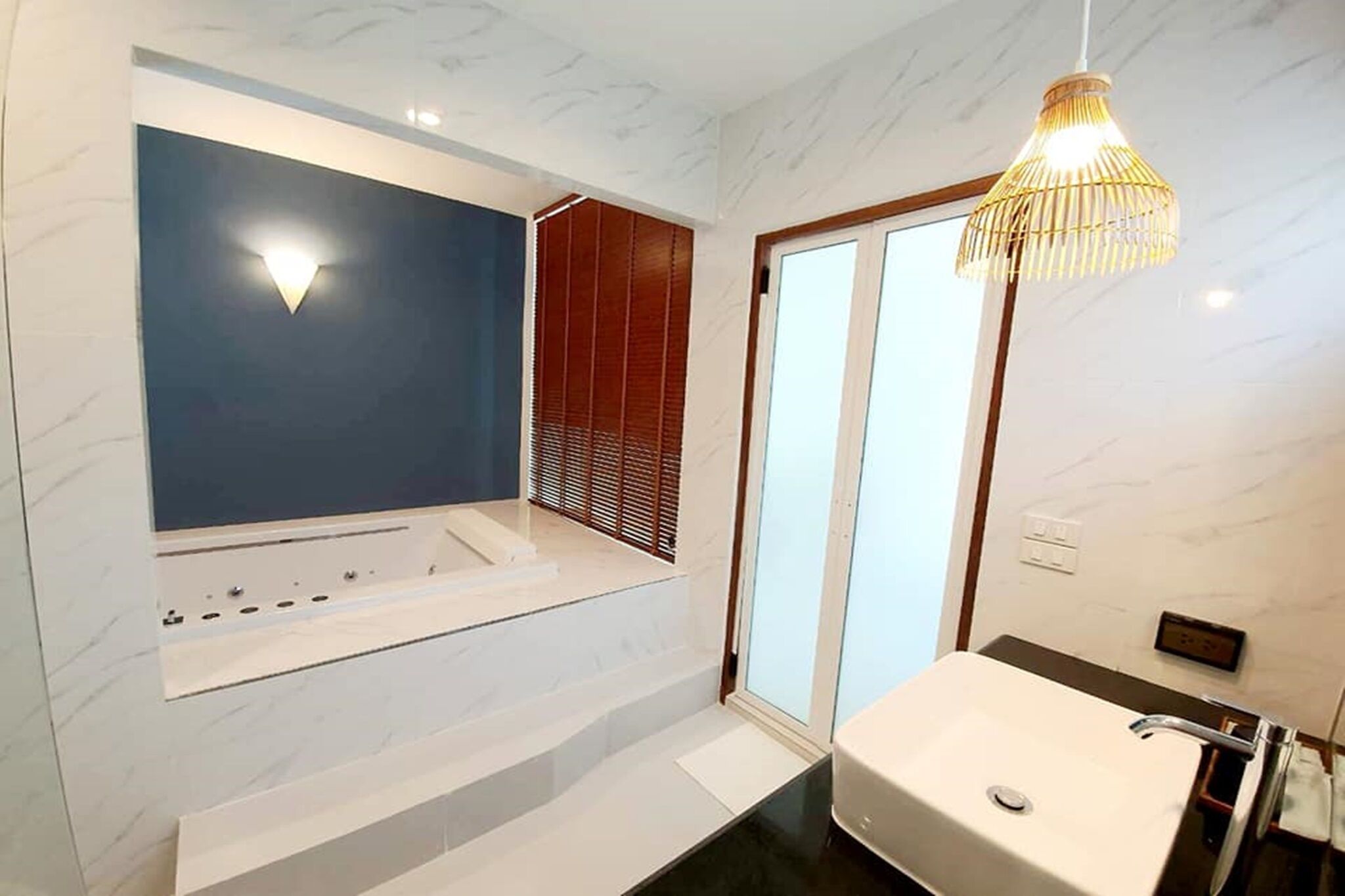 Uma casa de banho moderna com uma banheira grande, uma pia separada e cabine de duche em vidro.