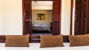 Um quarto com uma cama, uma porta de madeira e um quadro na parede.