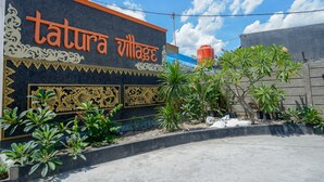 Um edifício com uma placa que diz "tatura village" e padrões decorativos nas paredes.