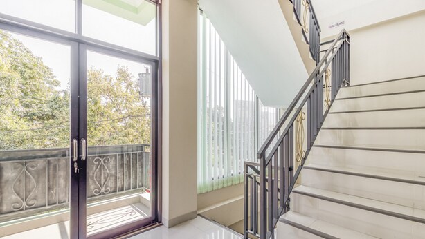 Um interior moderno com escada, janelas amplas e varanda.