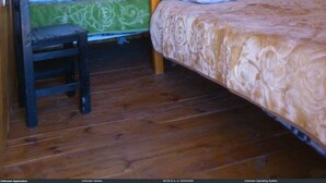 Uma cabana com duas beliches de madeira, uma pequena mesa e uma janela com vista para árvores.