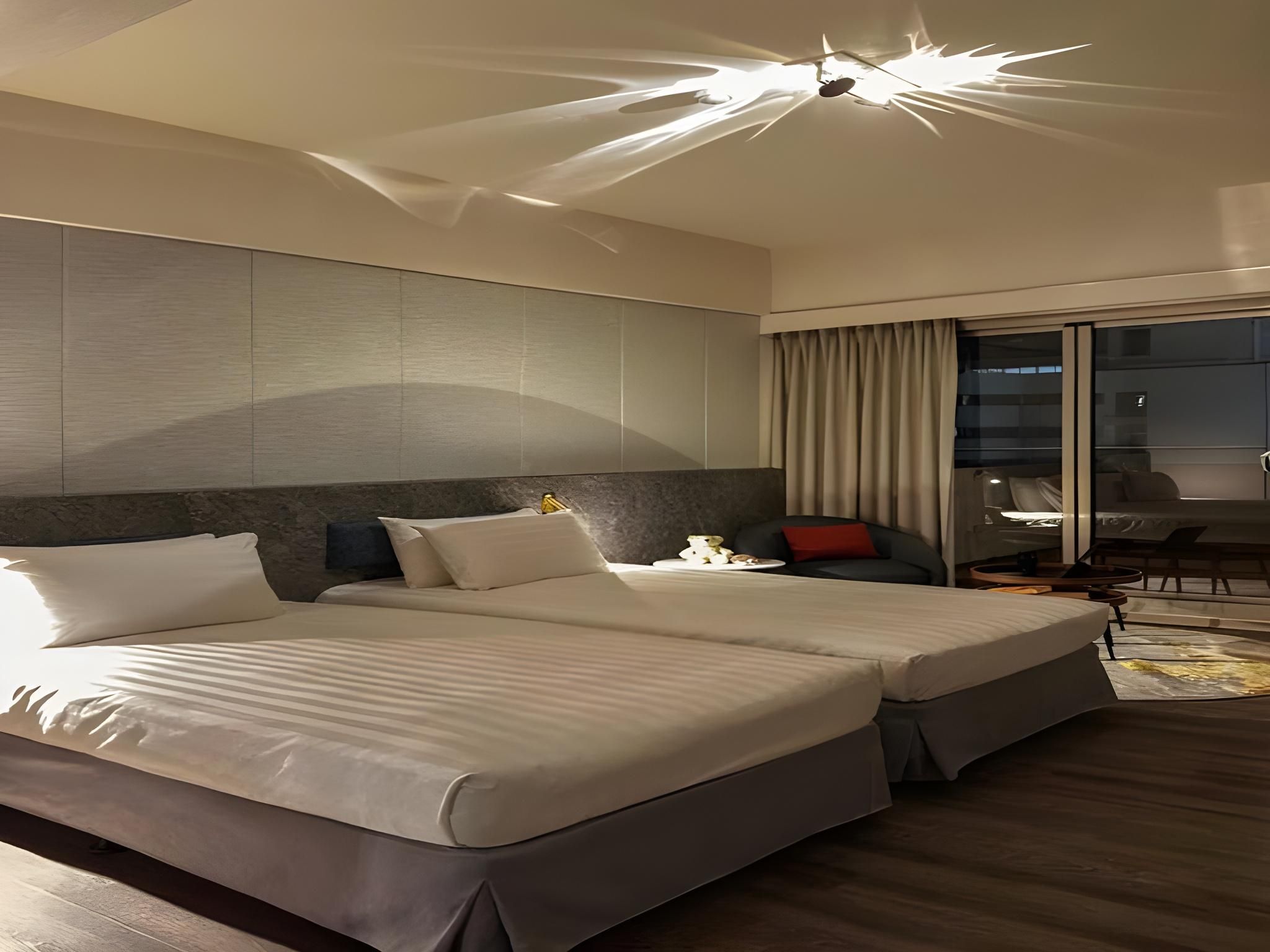 Quarto de hotel moderno com uma cama grande, uma escrivaninha e uma cadeira.