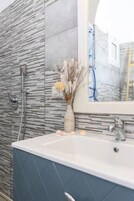 Quarto Duplo Deluxe | Casa de banho | Um polibã, um chuveiro fixo, artigos de higiene pessoal grátis