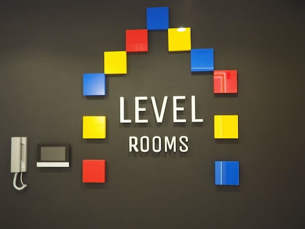 Paredes com o texto "LEVEL ROOMS" e uma série de blocos coloridos dispostos em um padrão.