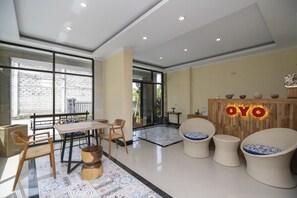 Um interior moderno com balcão de recepção, mobiliário de vime e piso estampado.