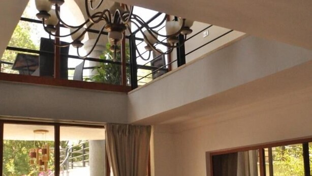 Quarto com claraboia, janelas amplas e ventoinha no teto.