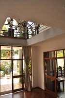 Quarto com claraboia, janelas amplas e ventoinha no teto.