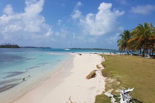 Na praia, areia branca, prática de mergulho livre no local 