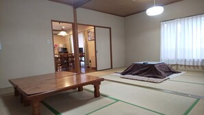 Um quarto japonês tradicional com tatames, uma mesa de madeira baixa e um futon.