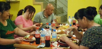 Um grupo de pessoas jantando à mesa, com diversos pratos e bebidas.