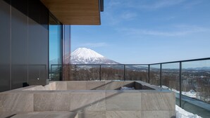 Terraço moderno ao ar livre com vista para uma montanha coberta de neve.