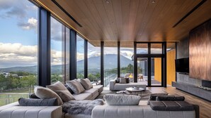 Uma sala de estar moderna com uma janela grande, um conjunto de sofás e uma lareira.