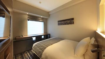 Quarto de hotel com uma cama, uma escrivaninha, janela com persianas e uma obra de arte na parede.