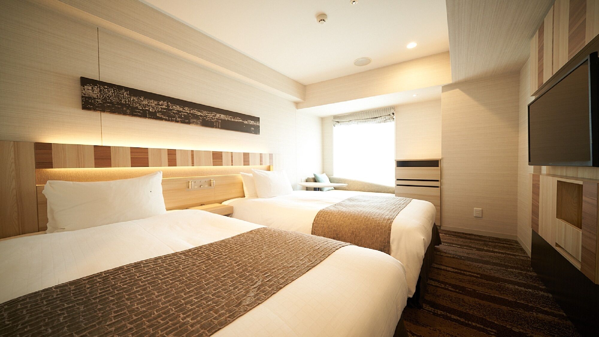 Quarto de hotel com duas camas, televisão de tela plana, janela com cortinas e uma obra de arte pendurada na parede.