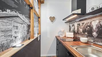 Um frigorífico, uma placa de cozinha, uma cafeteira/bule