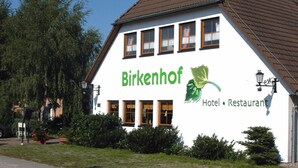 Um edifício com o nome "Birkenhof" e um logotipo de folha, indicando que se trata de um hotel e restaurante.