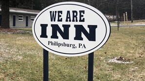 Um letreiro com a inscrição 'WE ARE INN' e 'Philipsburg, PA' abaixo.