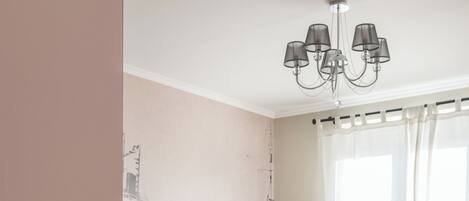 Um quarto moderno com cama, um candelabro e um mural da paisagem urbana na parede.