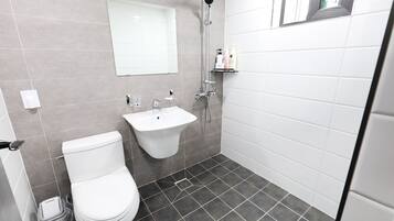 Uma casa de banho moderna com sanita, lavatório e chuveiro.