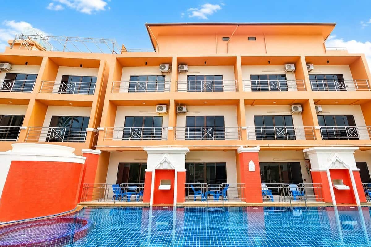 Um hotel com vários andares, piscina, varandas e aparelhos de ar condicionado.