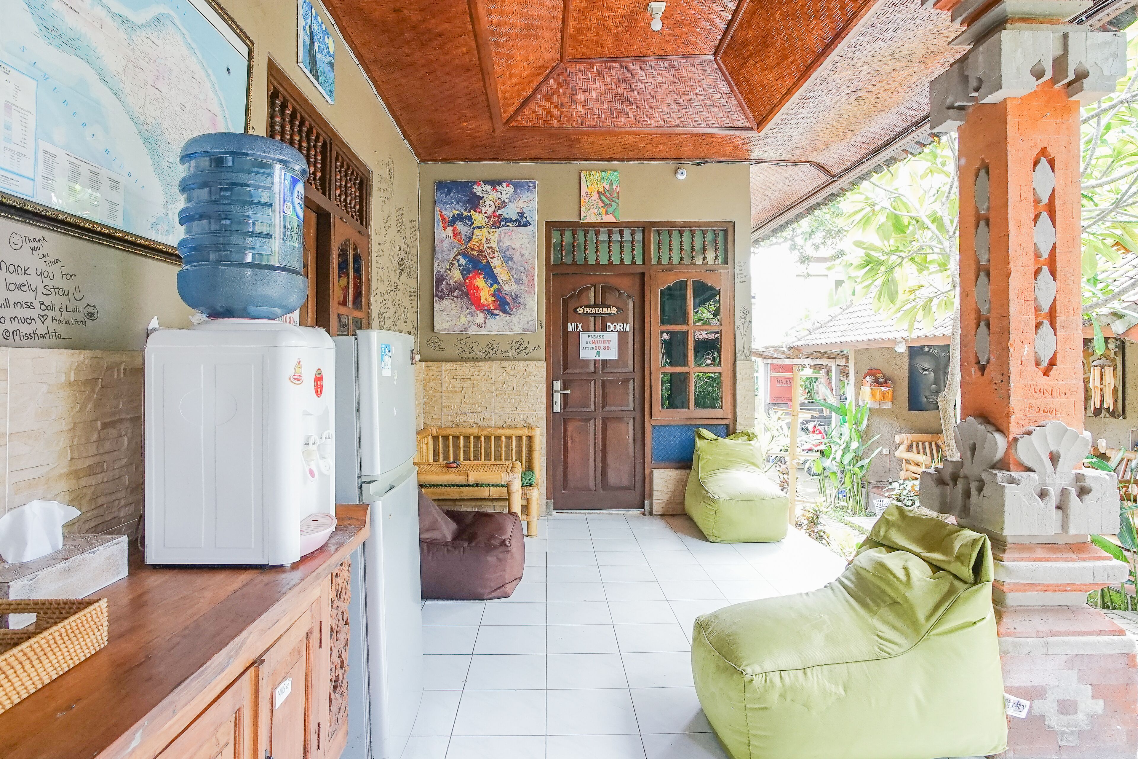 Um interior acolhedor com um dispensador de água, um banco de madeira e uma poltrona de feijão verde.