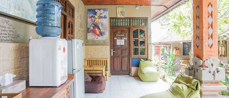 Um interior acolhedor com um dispensador de água, um banco de madeira e uma poltrona de feijão verde.
