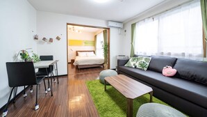 Uma sala moderna com sofá, mesa de jantar e cama.