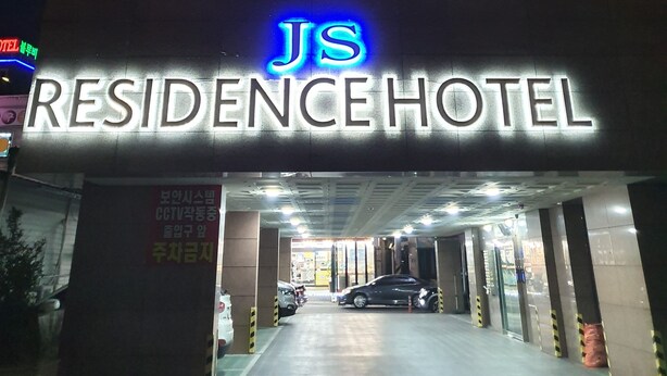 Um edifício com uma placa que diz 'JS RESIDENCE HOTEL'.