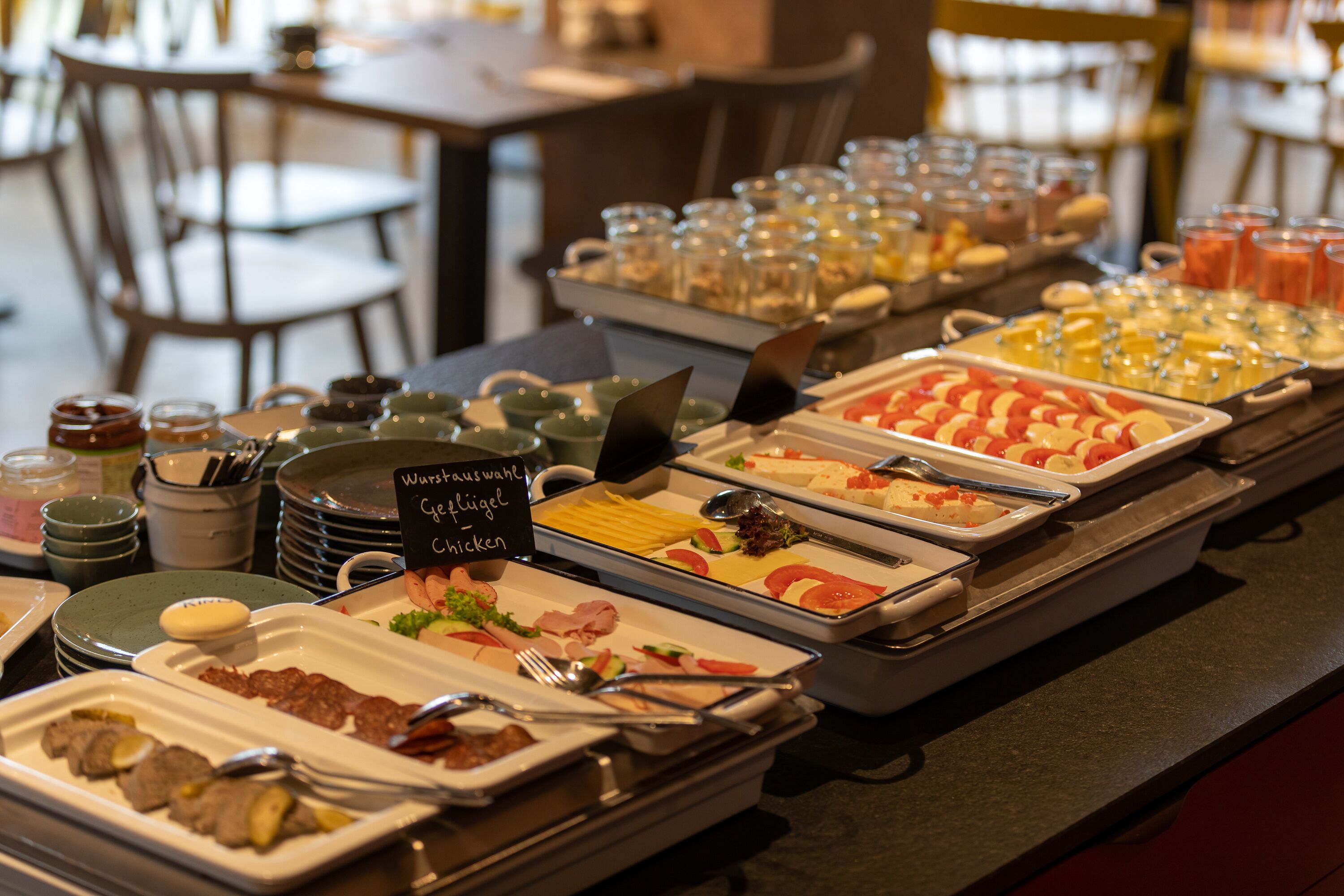 Buffet com diversas opções de comida e utensílios.