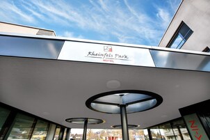 Exterior do Motel Rheinfels Park com design moderno, apresentando uma placa de destaque e claraboias circulares.