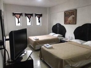 Quarto de hotel com duas camas, uma televisão e um quadro na parede.