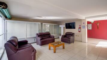 Uma sala de estar com dois sofás, uma mesa de centro e uma televisão.