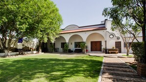 Um edifício com fachada branca, janelas em arco e telhado de telhas vermelhas.